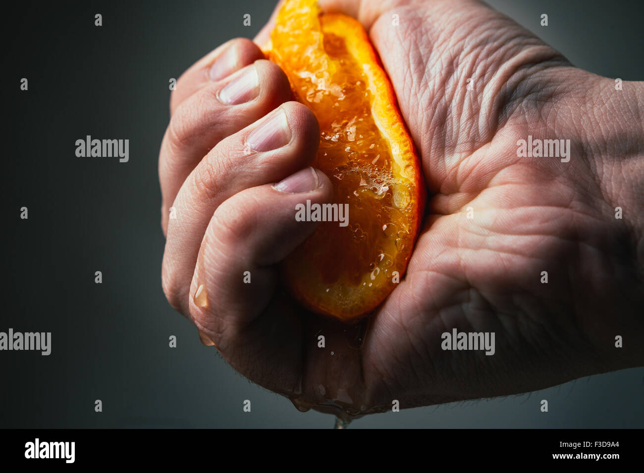 man dramatic squeezes orange. Concept squeezed a man is tired from work ...