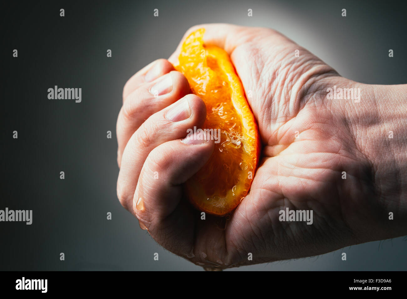 man dramatic squeezes orange. Concept squeezed a man is tired from work ...