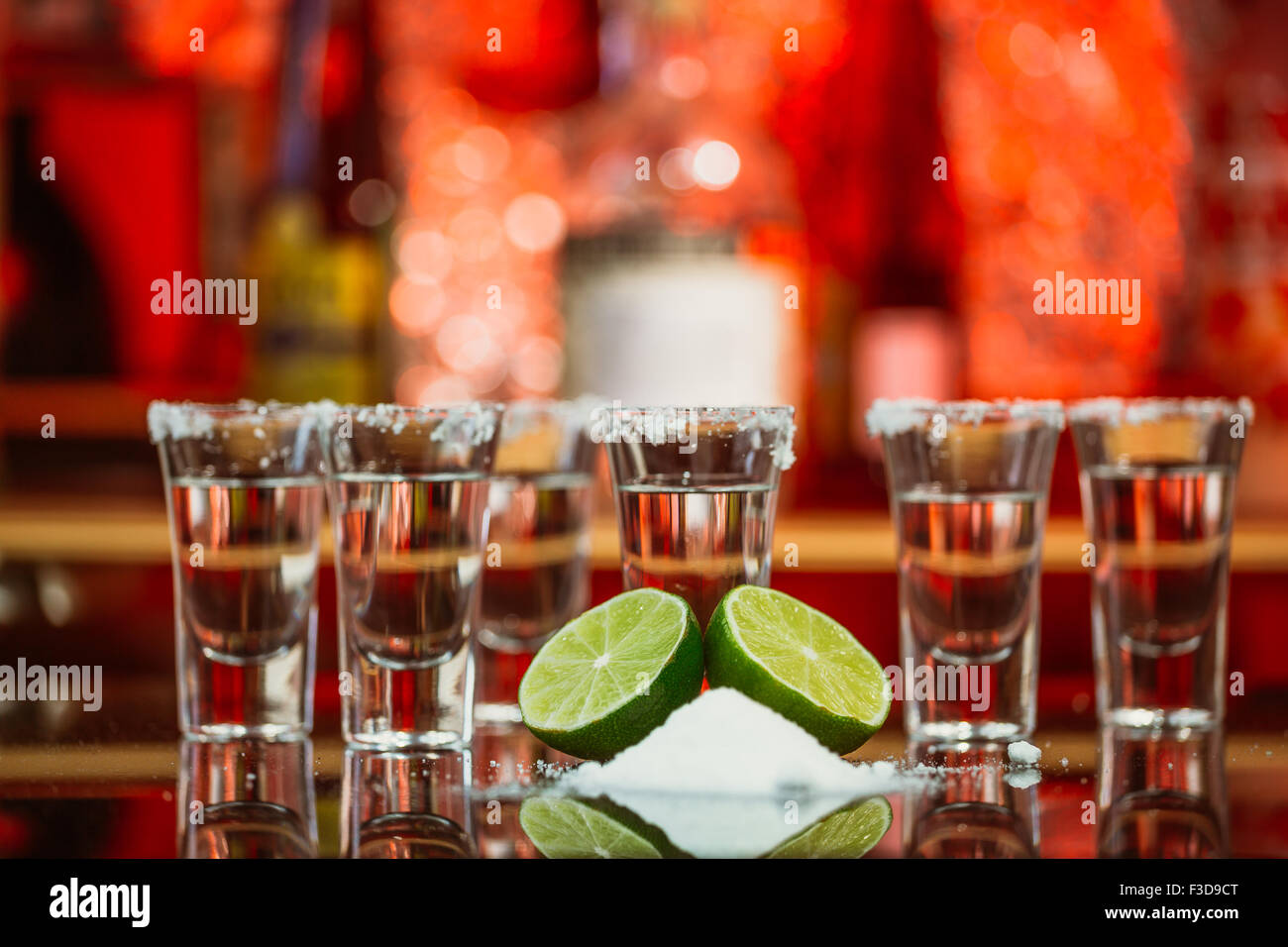 two shots of tequila with lime and salt on a wooden table bar on the ...