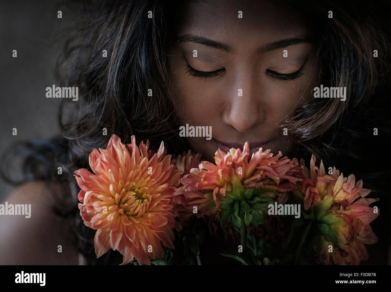Young woman smelling flowers Stock Photo - Alamy