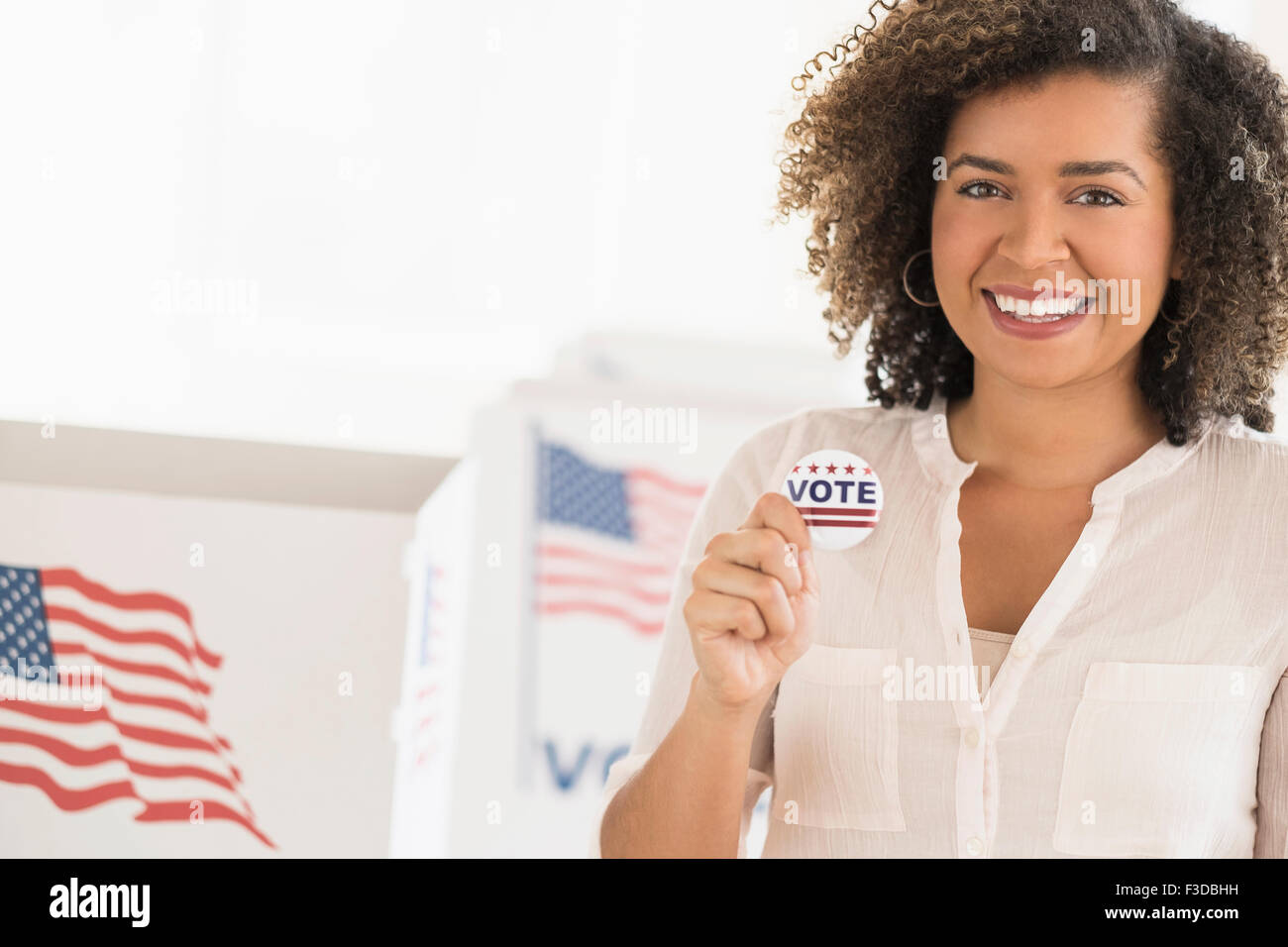 Young woman holding voting badge and smiling Stock Photo - Alamy