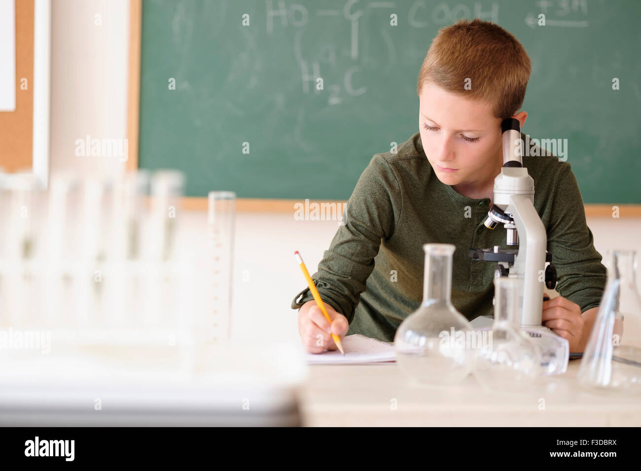 Boy (8-9) taking notes in classroom Stock Photo - Alamy