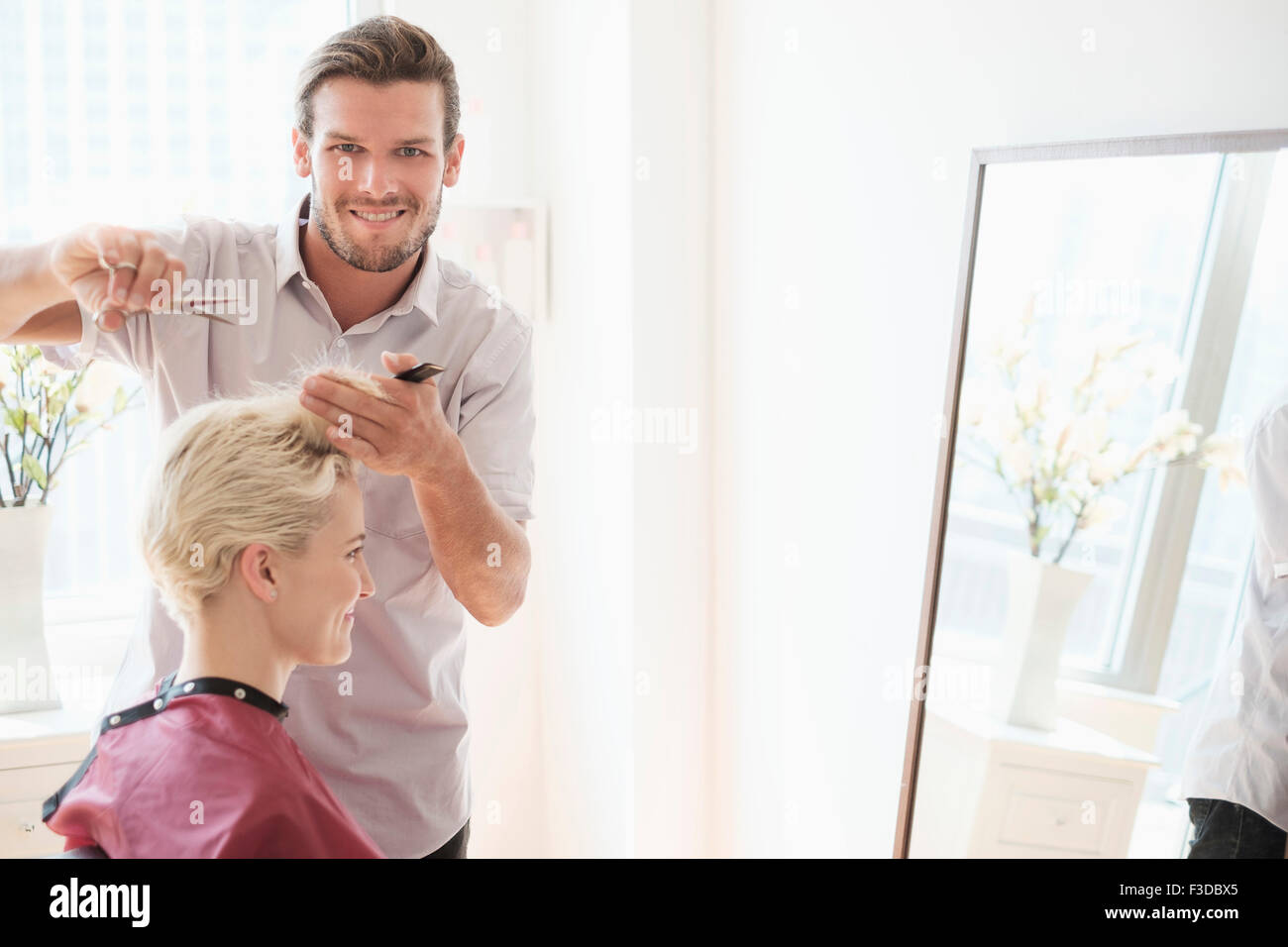 Portrait of hairdresser cutting woman's hair Stock Photo - Alamy