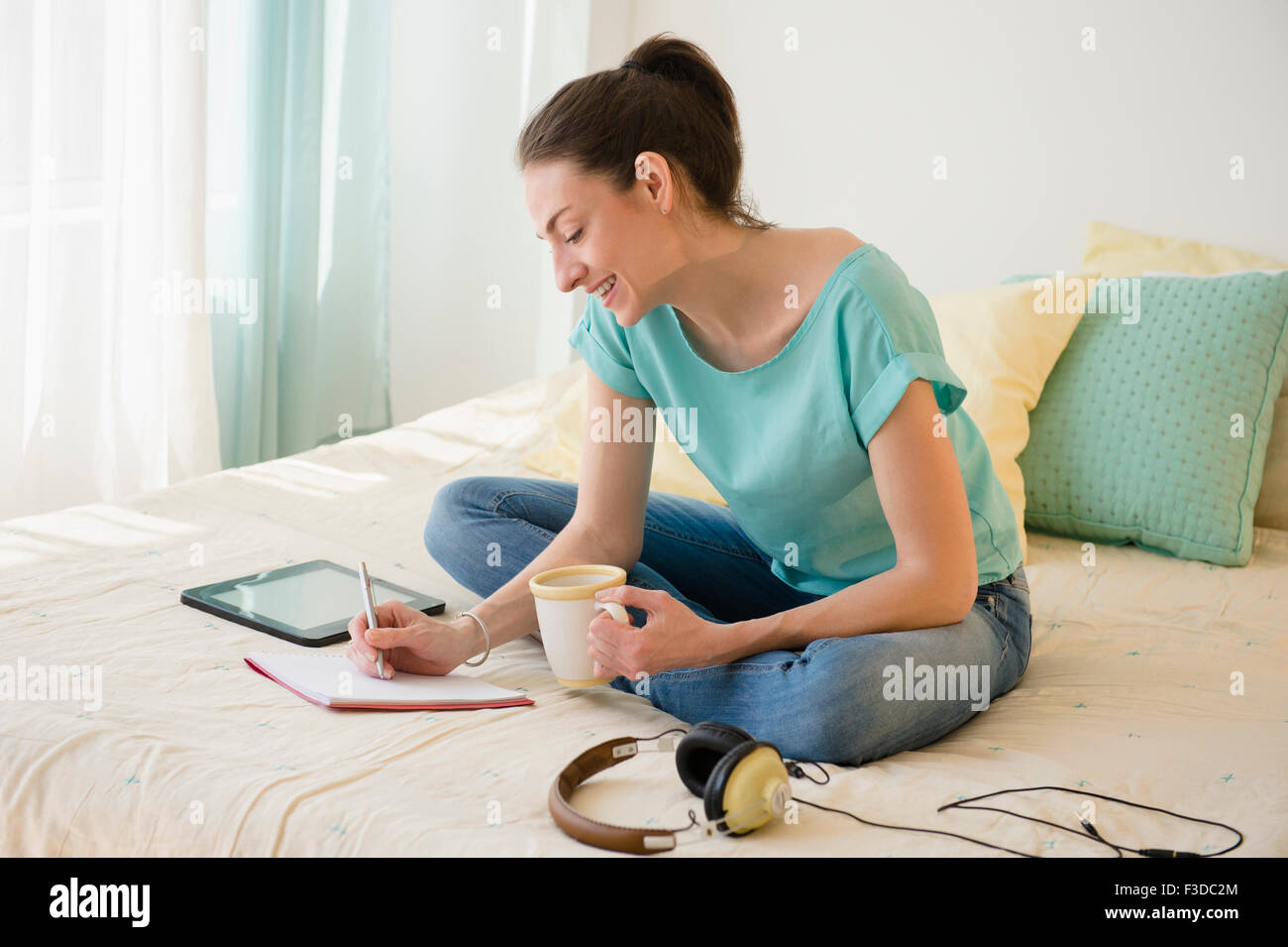 Woman in bedroom working Stock Photo - Alamy