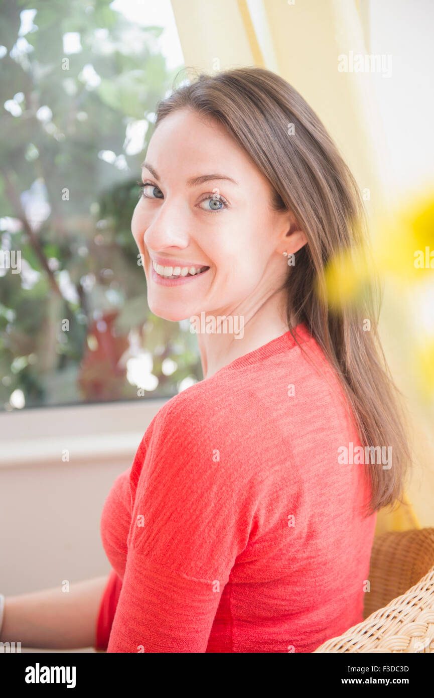 Portrait of smiling woman near window Stock Photo - Alamy