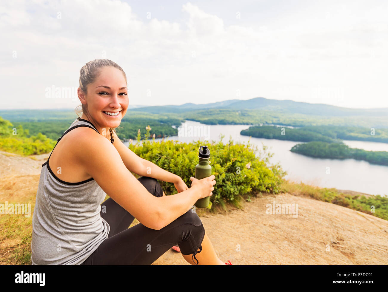 Smiling young female hiker resting Stock Photo - Alamy