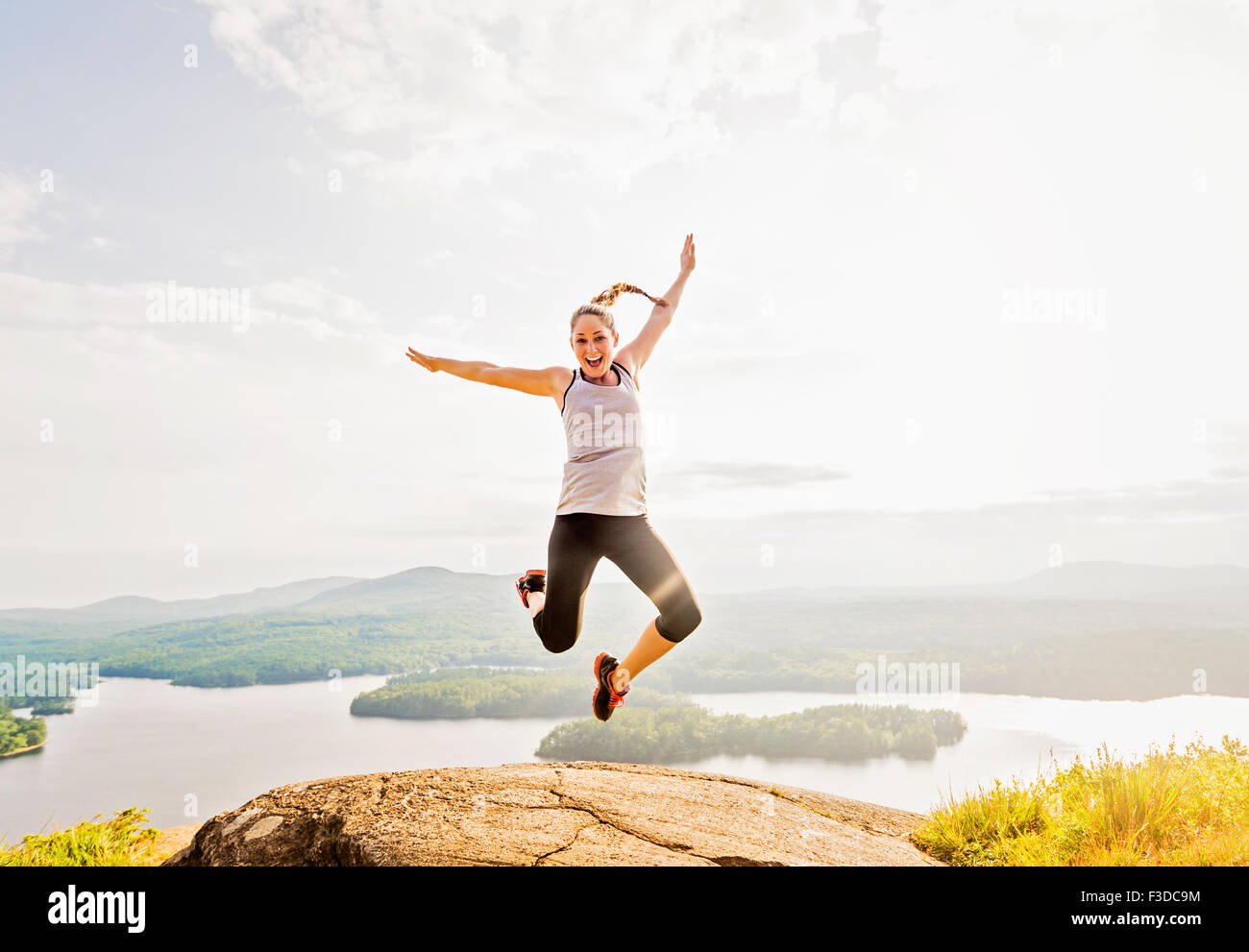 Young woman jumping over mountain top hi-res stock photography and ...