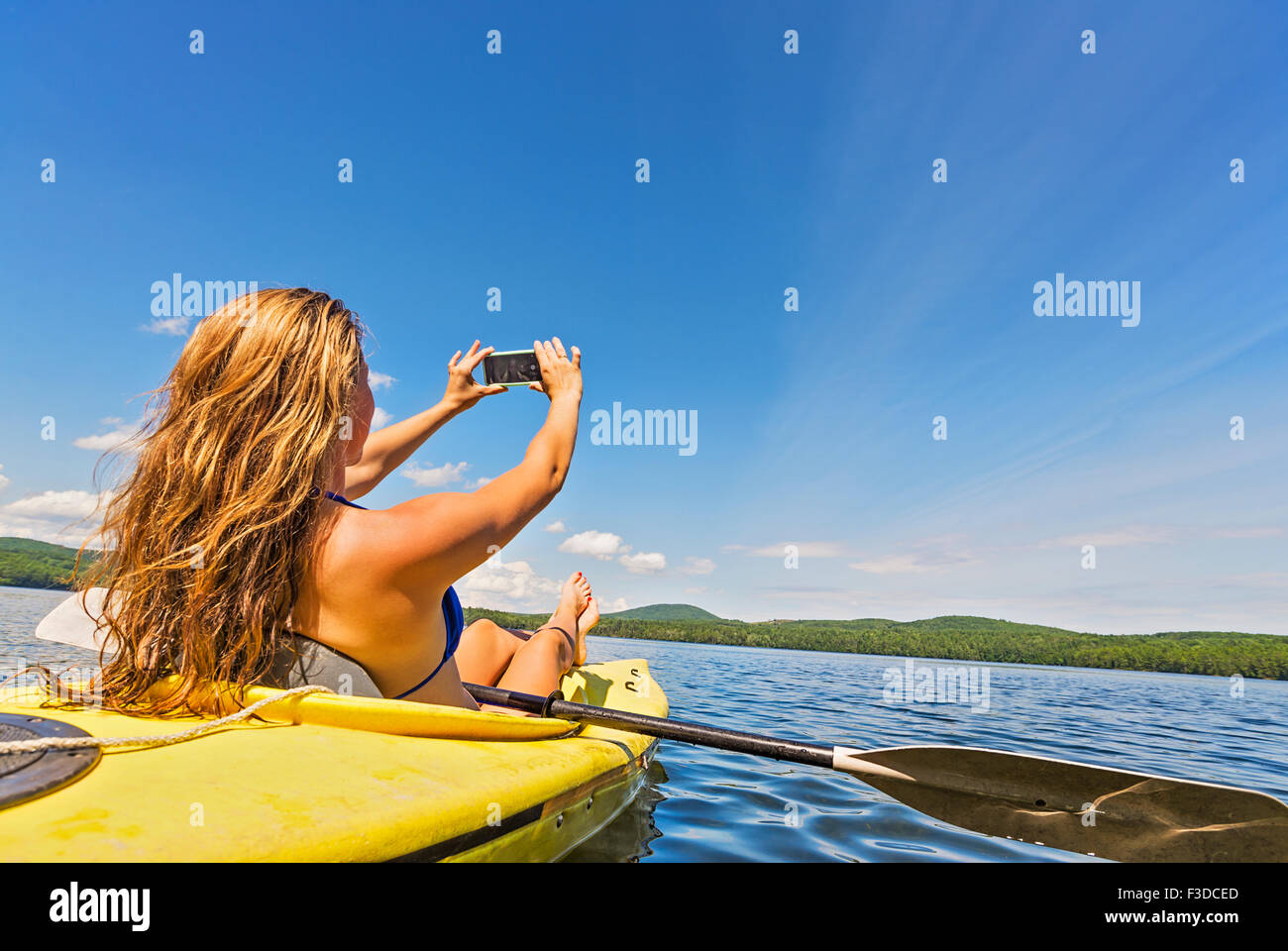Two Sexy Bikini Models In Swimwear Posing On Kayak On Tropical Beach