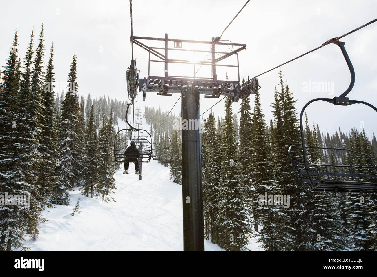 Man in ski lift, rear view Stock Photo - Alamy