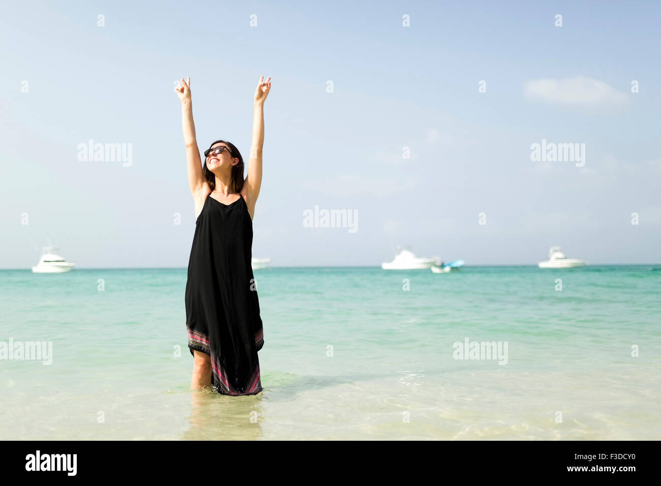 Woman with arms raised on beach hi-res stock photography and images - Alamy