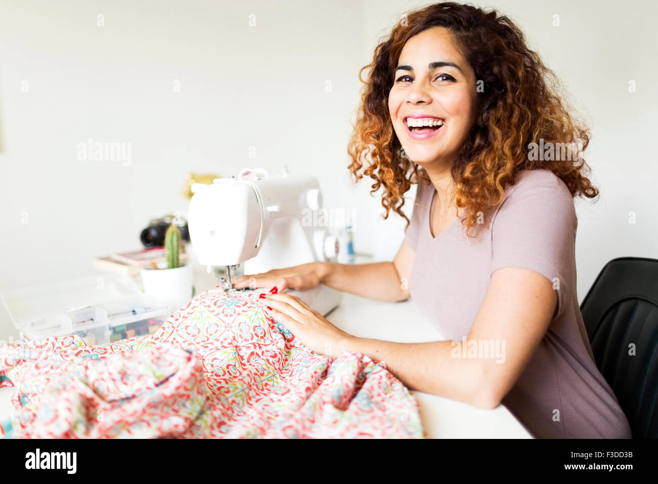 Woman using sewing machine Stock Photo - Alamy