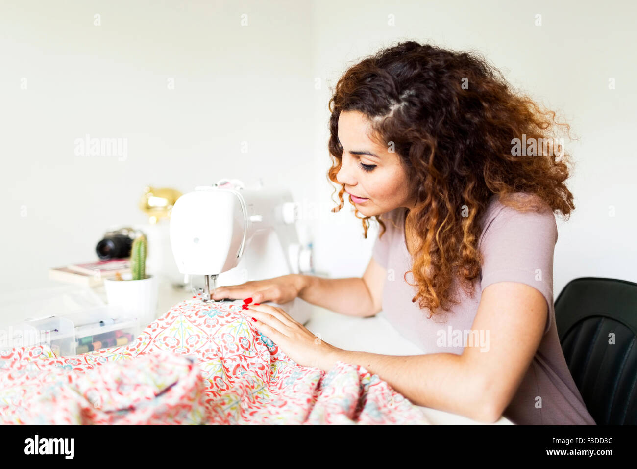 Woman using sewing machine Stock Photo - Alamy