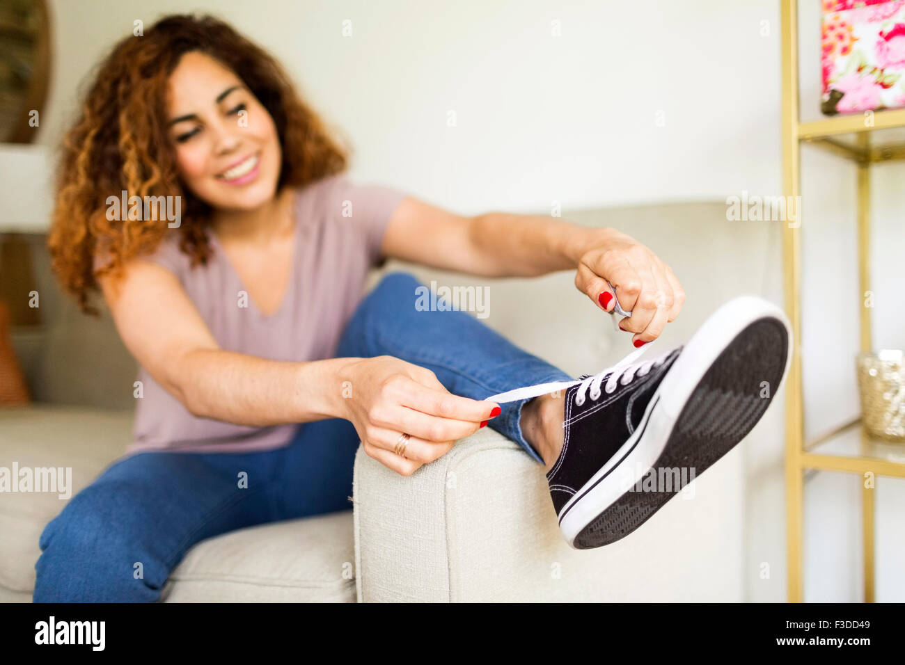 Woman putting on trainers Stock Photo - Alamy