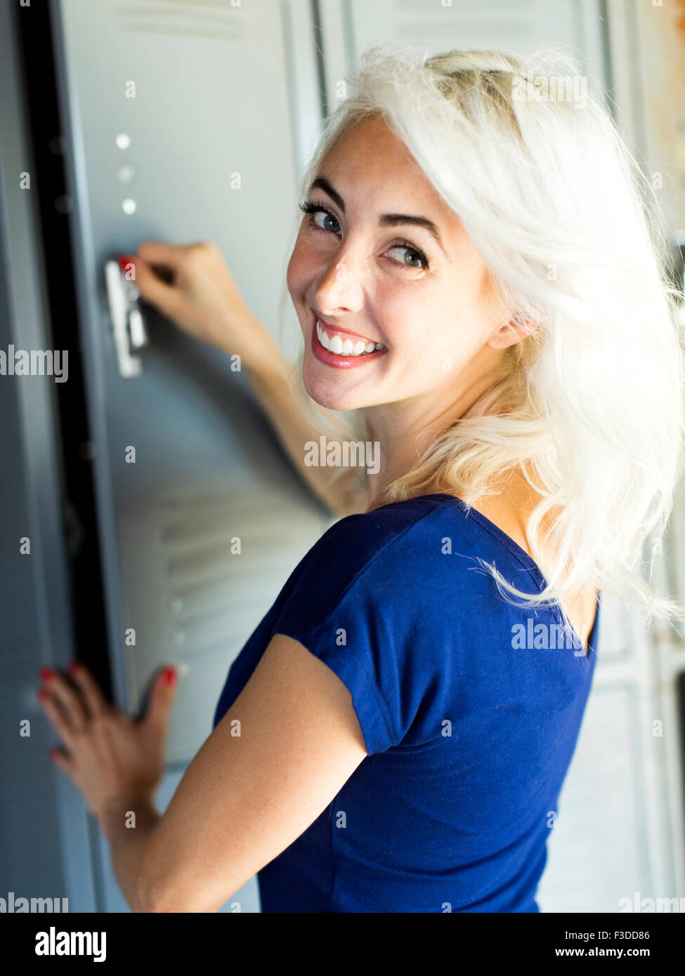 Woman opening locker Stock Photo - Alamy