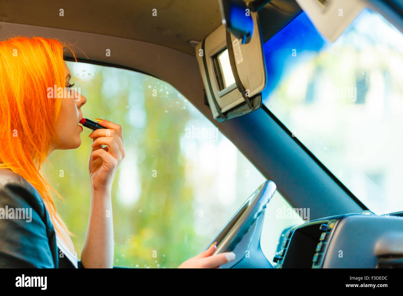 Concept of danger driving. Young woman driver red haired girl painting ...