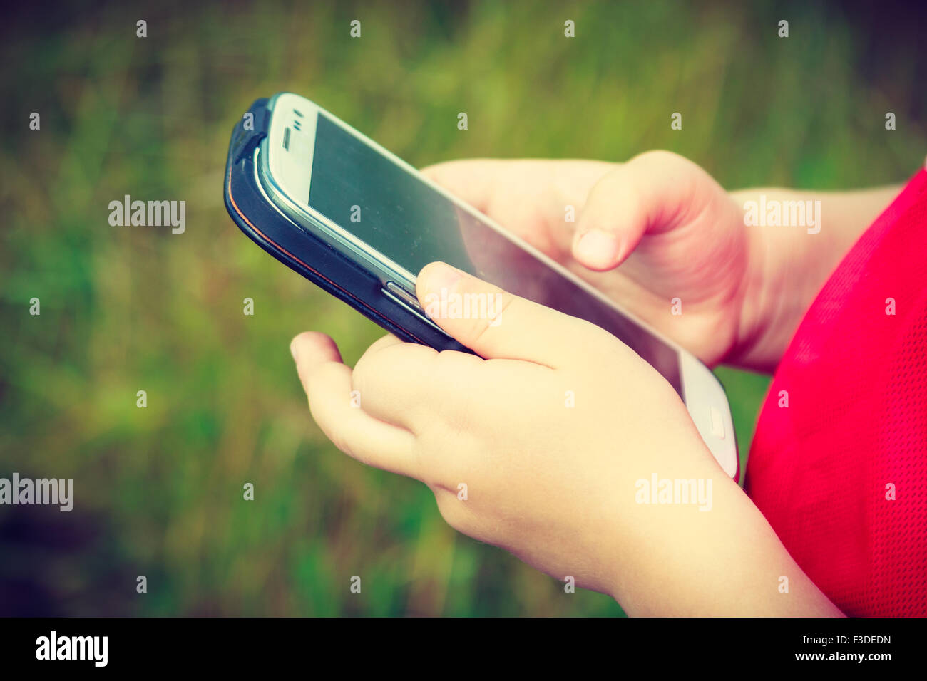 Little boy child kid playing games on smartphone mobile phone outdoor ...