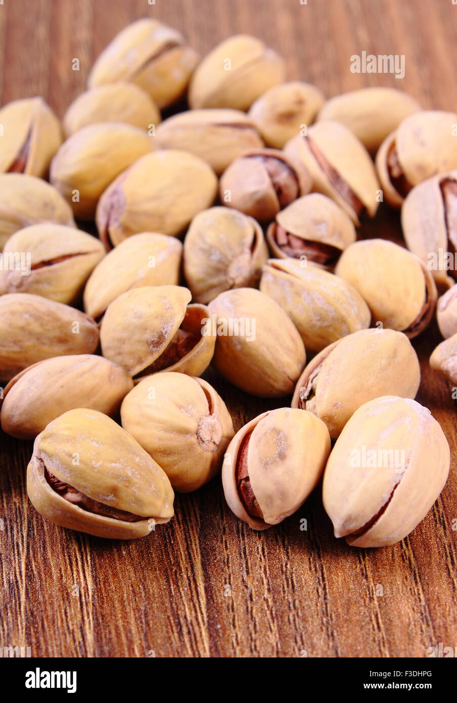 Roasted pistachio nuts on natural wooden table background, healthy food and nutrition Stock ...