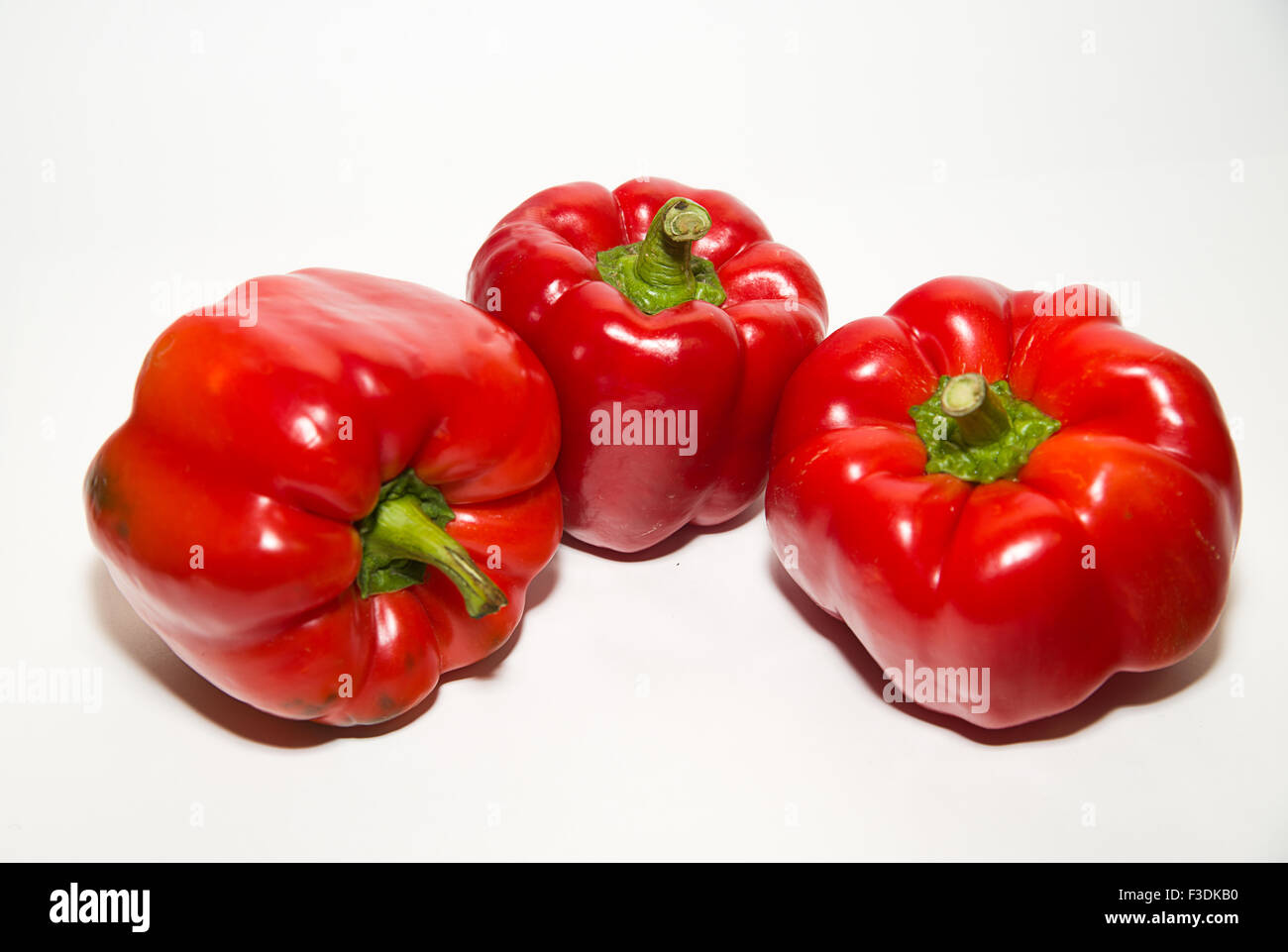 Three red peppers on a white background Stock Photo - Alamy