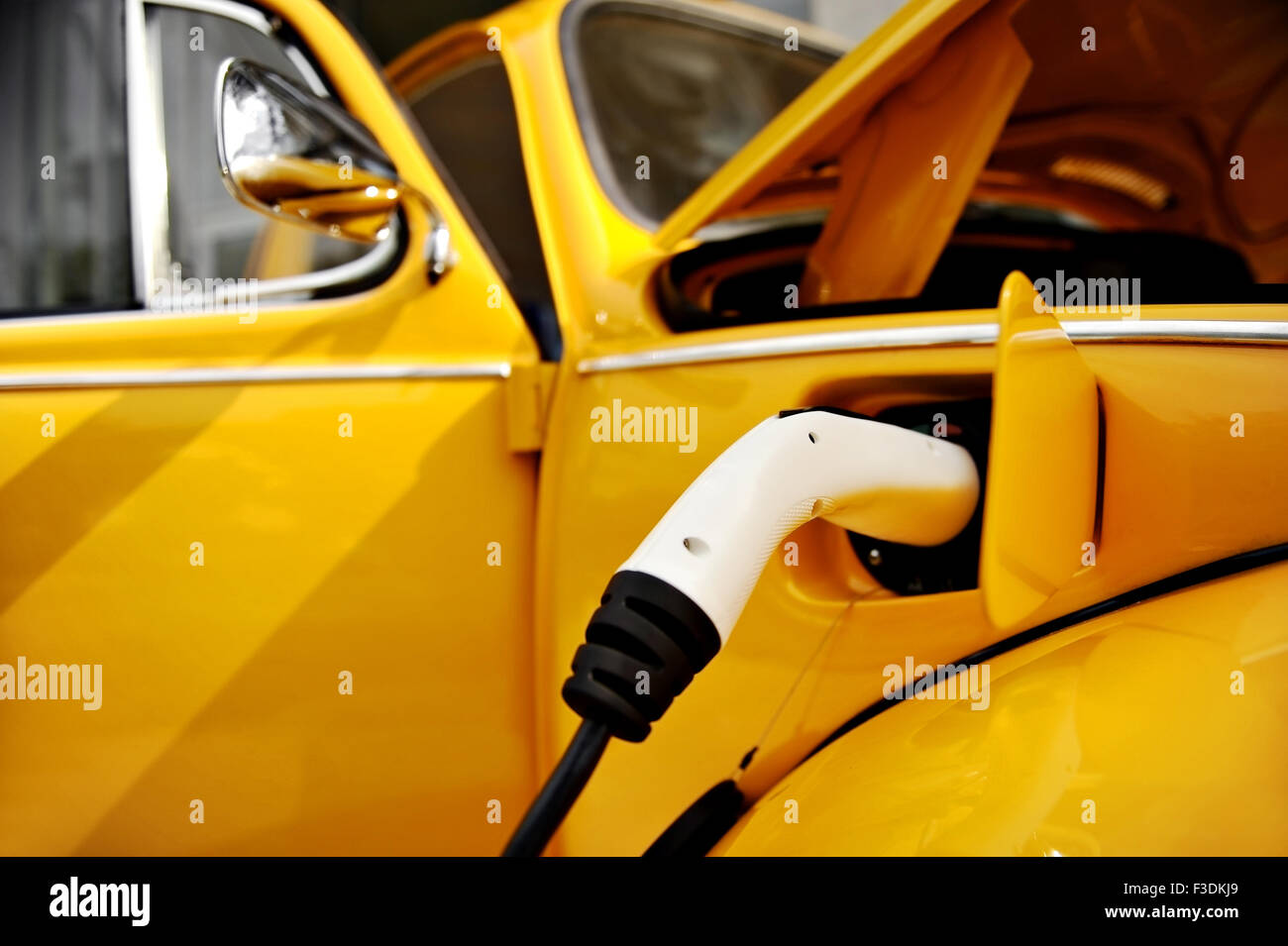 Detail shot with an electric plug in connected and charging a classic ...