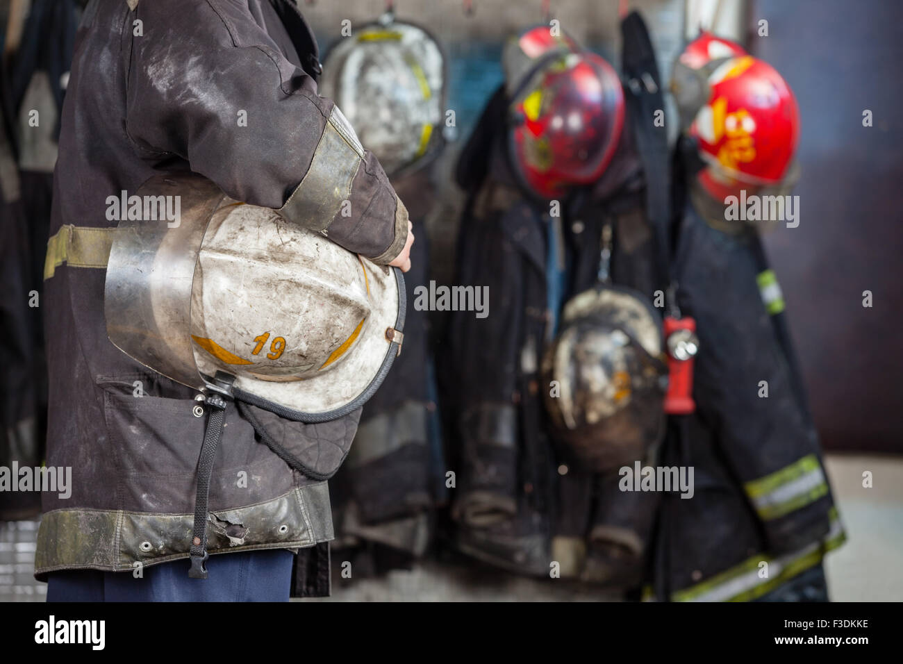 Worker Holding Helmet At Fire Station Stock Photo - Alamy