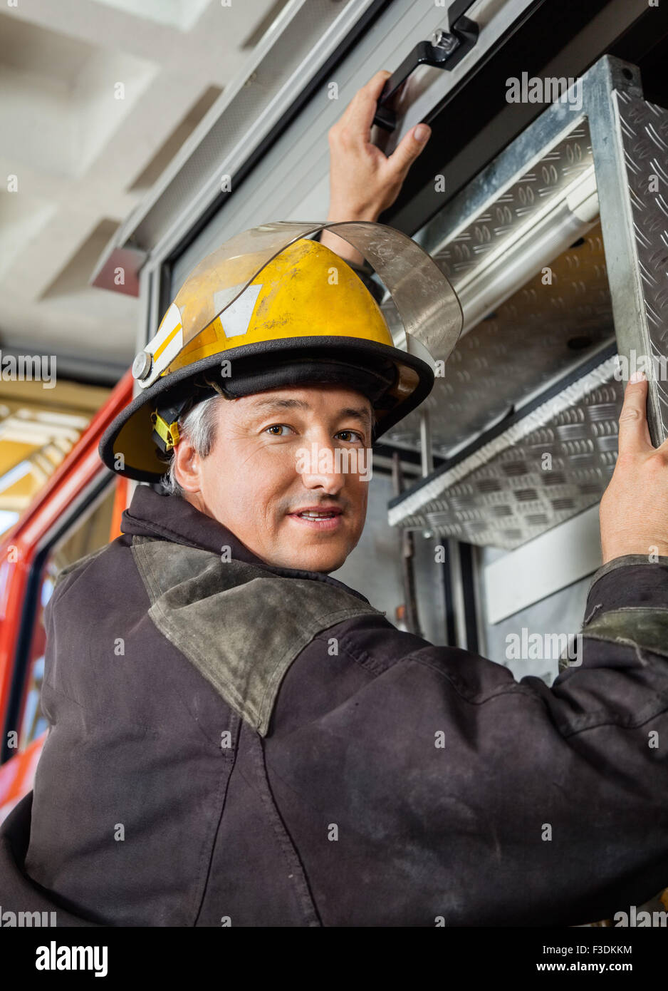 Confident Fireman Climbing Truck Stock Photo - Alamy
