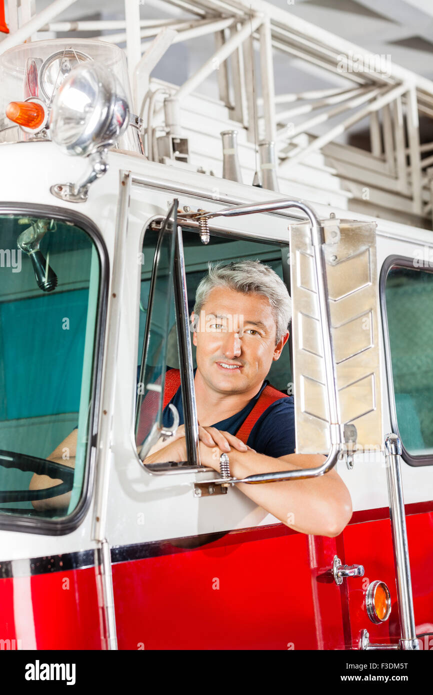 Confident Fireman Sitting In Firetruck Stock Photo - Alamy