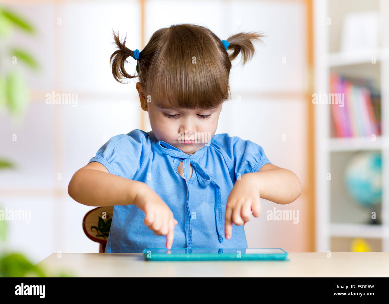child girl playing with a digital tablet pc at home Stock Photo - Alamy