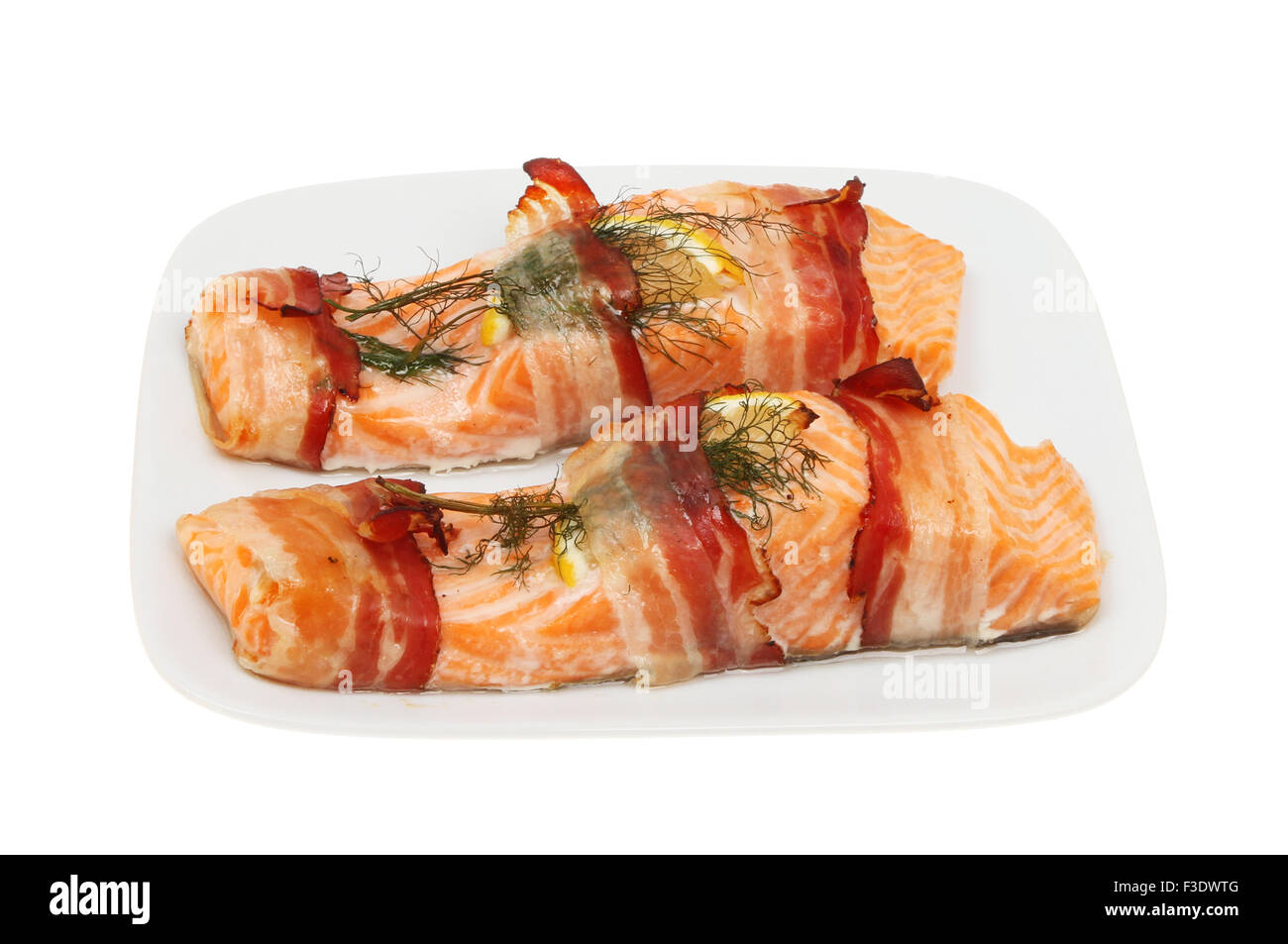 Two sea trout fillets cooked with pancetta, fennel and lemon on a plate ...