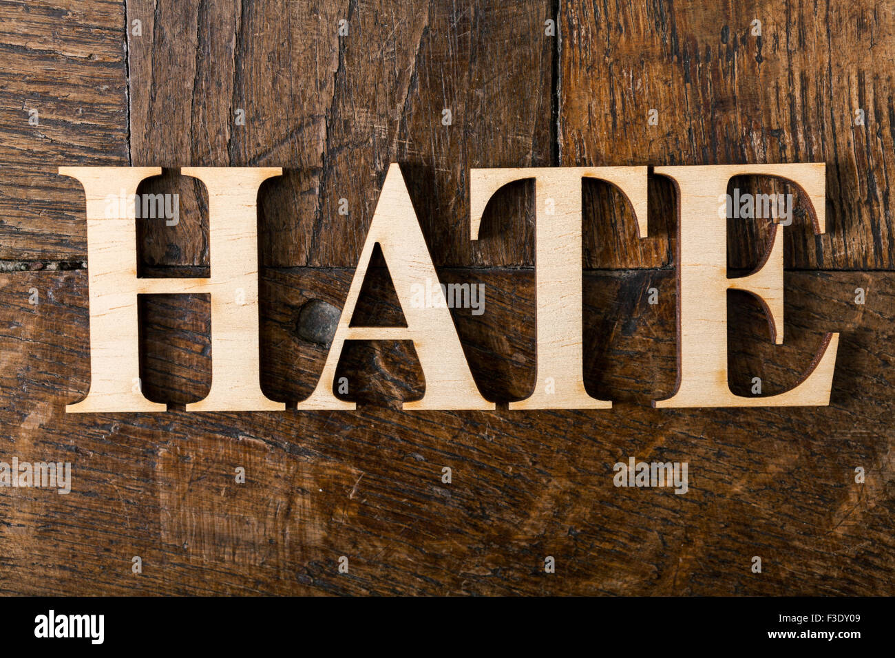 Wooden letters forming word HATE written on old vintage wooden plates ...