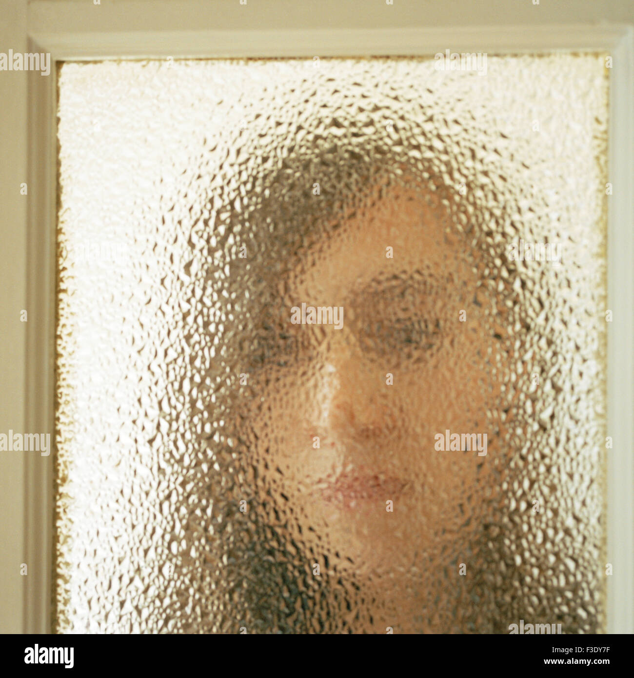Woman looking through window Stock Photo - Alamy