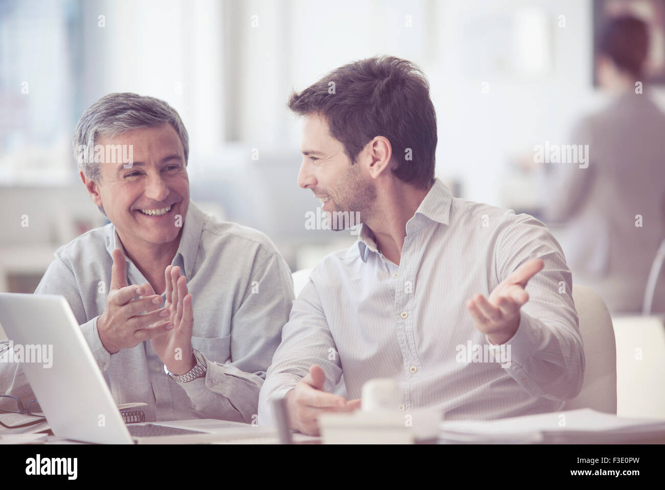 Colleagues talking, one man clapping Stock Photo - Alamy