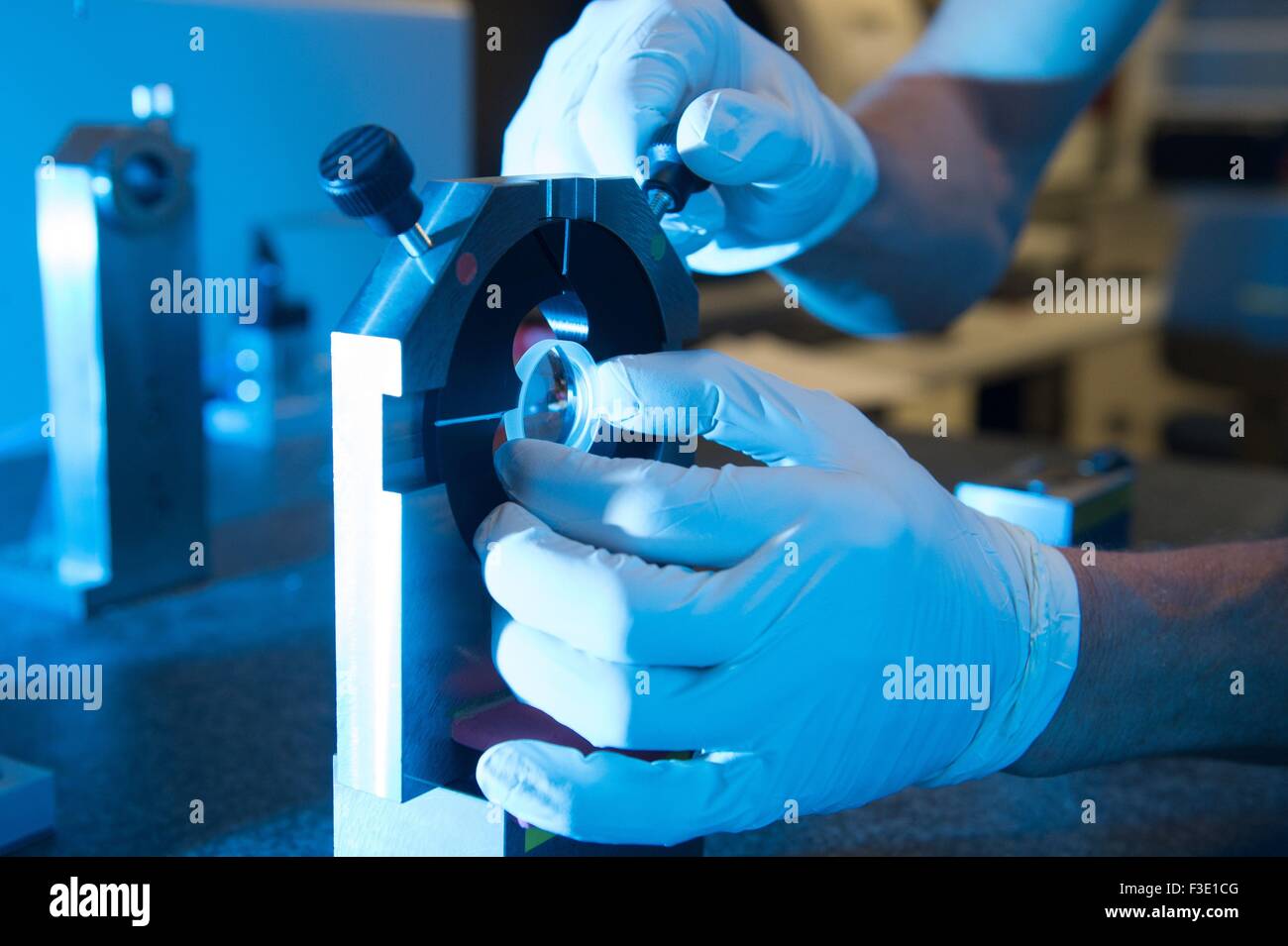 An employee holds an aspheric lens during the tactile measurement in ...
