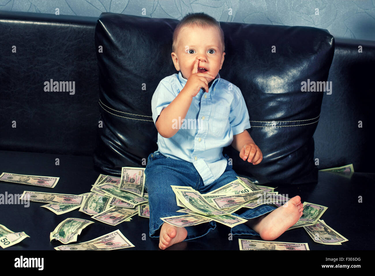 Thinking little boy with fake money Stock Photo - Alamy