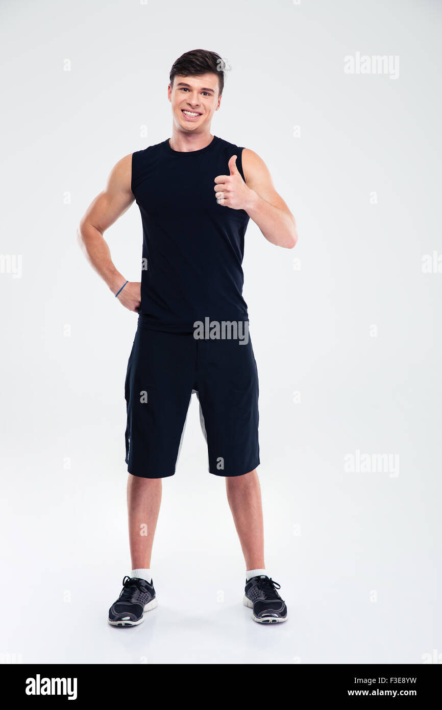 Full length portrait of a happy fitness man showing thumb up isolated ...