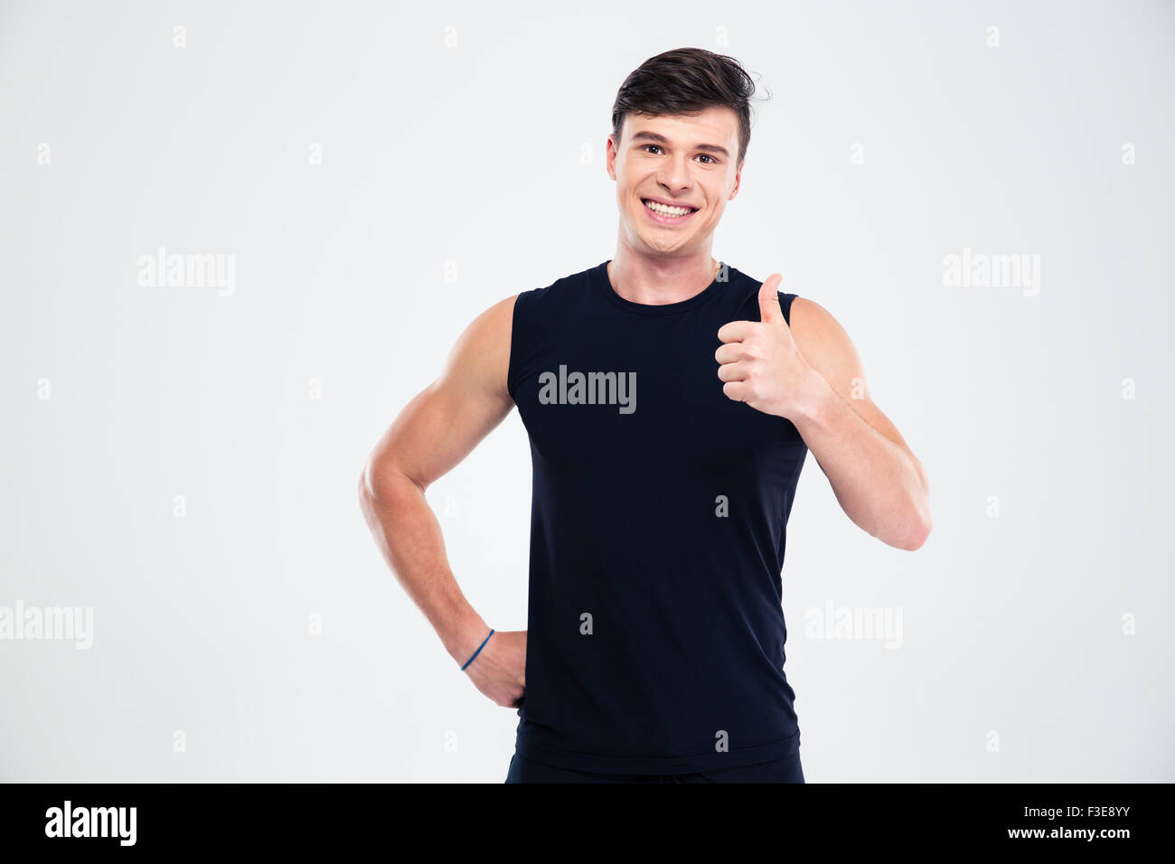 Portrait of a smiling sports man showing thumb up isolated on a white ...