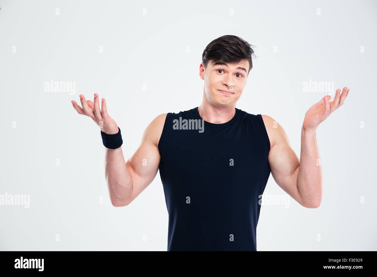 Portrait of a fitness man shrugging shoulders isolated on a white ...