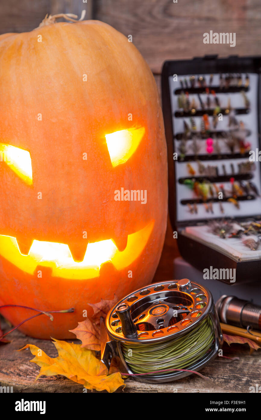 halloween pumpkin head with fly-fishing tackles on wooden boards ...