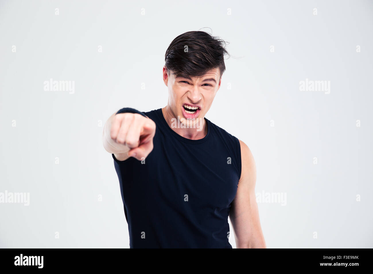 Portrait of angry fitness man pointing finger at camera isolated on a ...