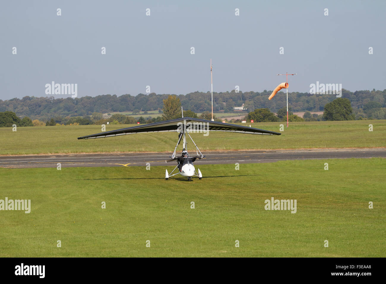 Microlight aircraft with two people on board on the grass at ...
