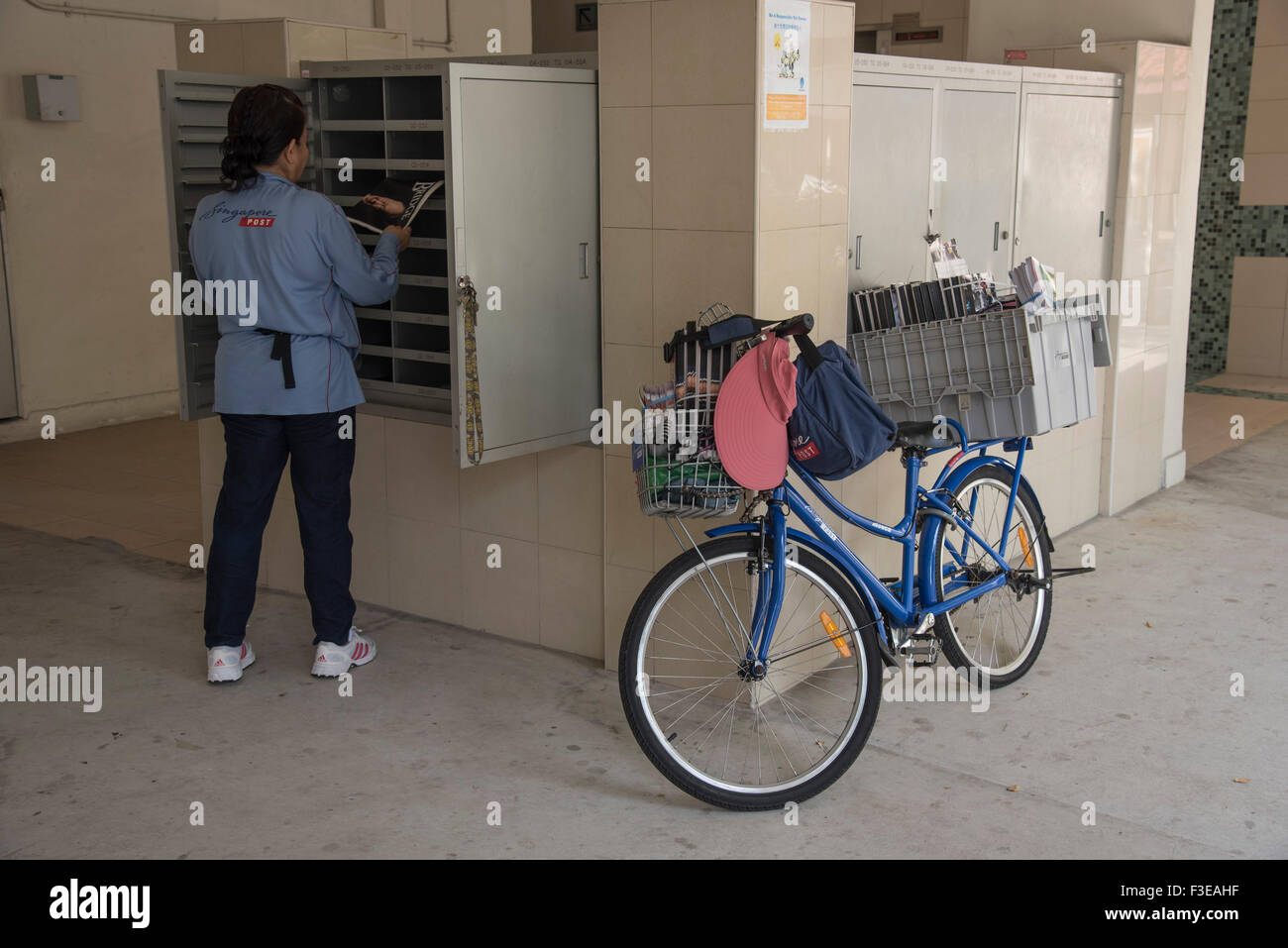 Post-woman delivering letters in Singapore Stock Photo - Alamy