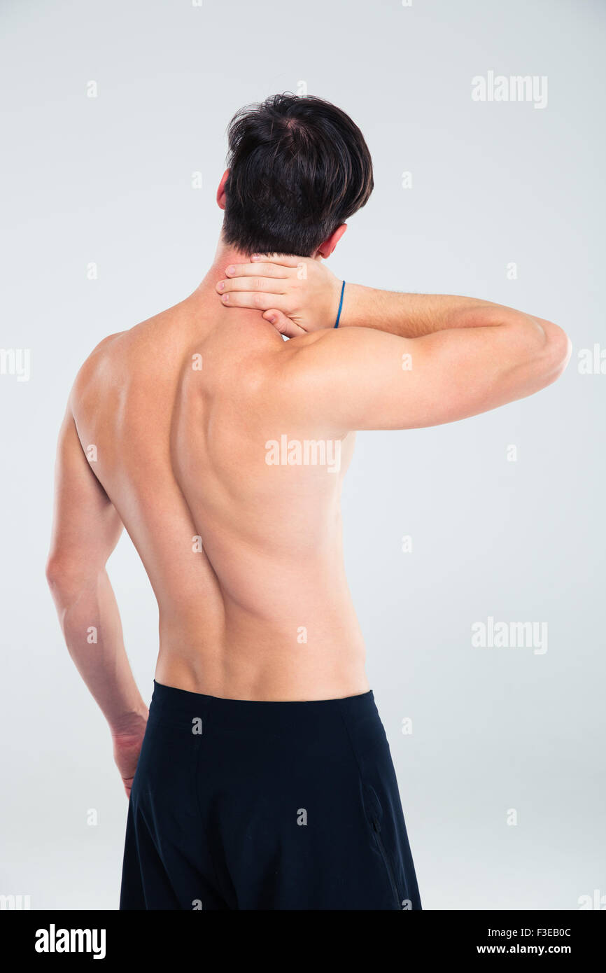 Back view portrait of a man having neck pain isolated on a white ...