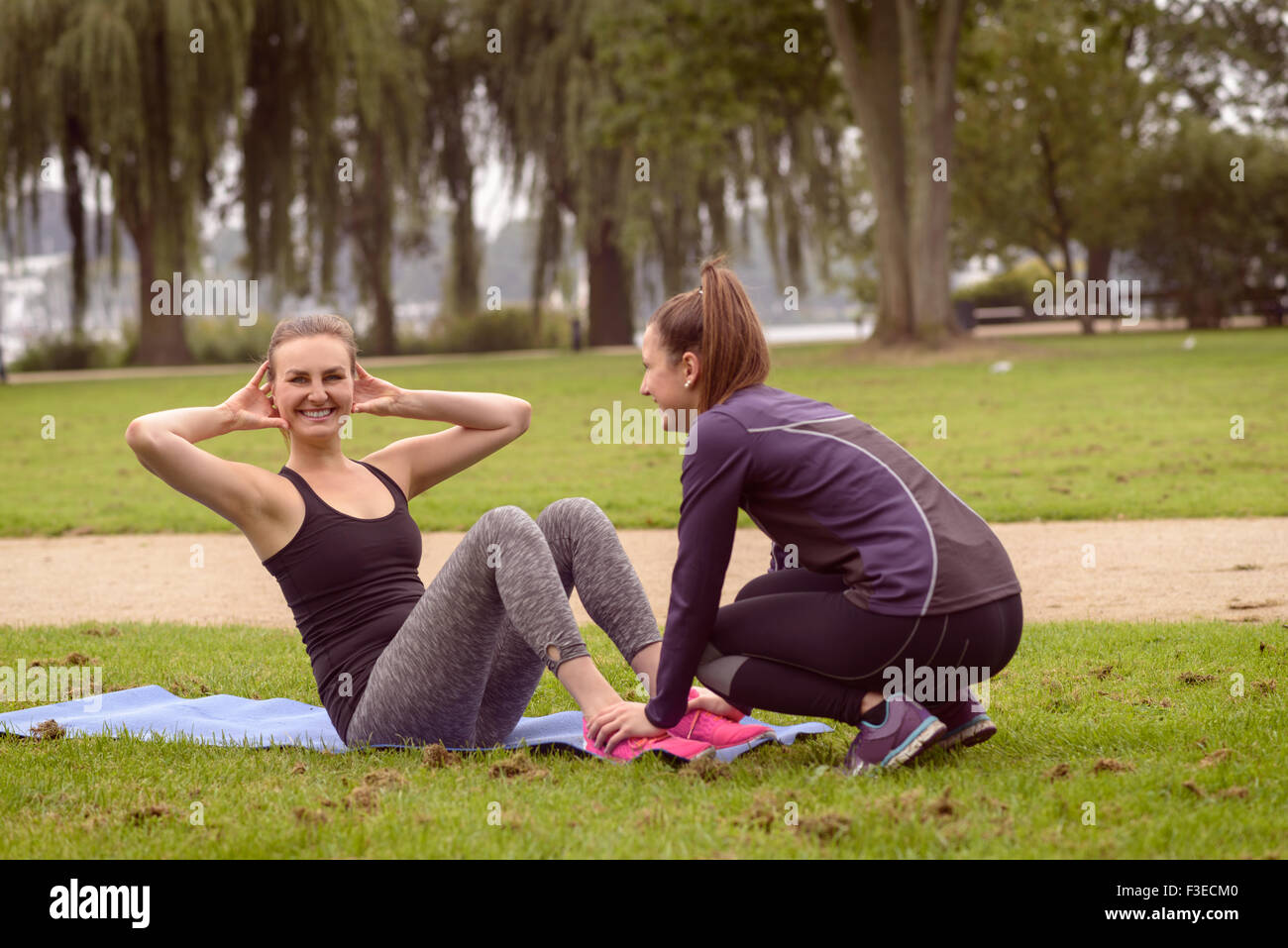 Happy Athletic Woman Smiling at the Camera While Doing Curl Up Exercise ...