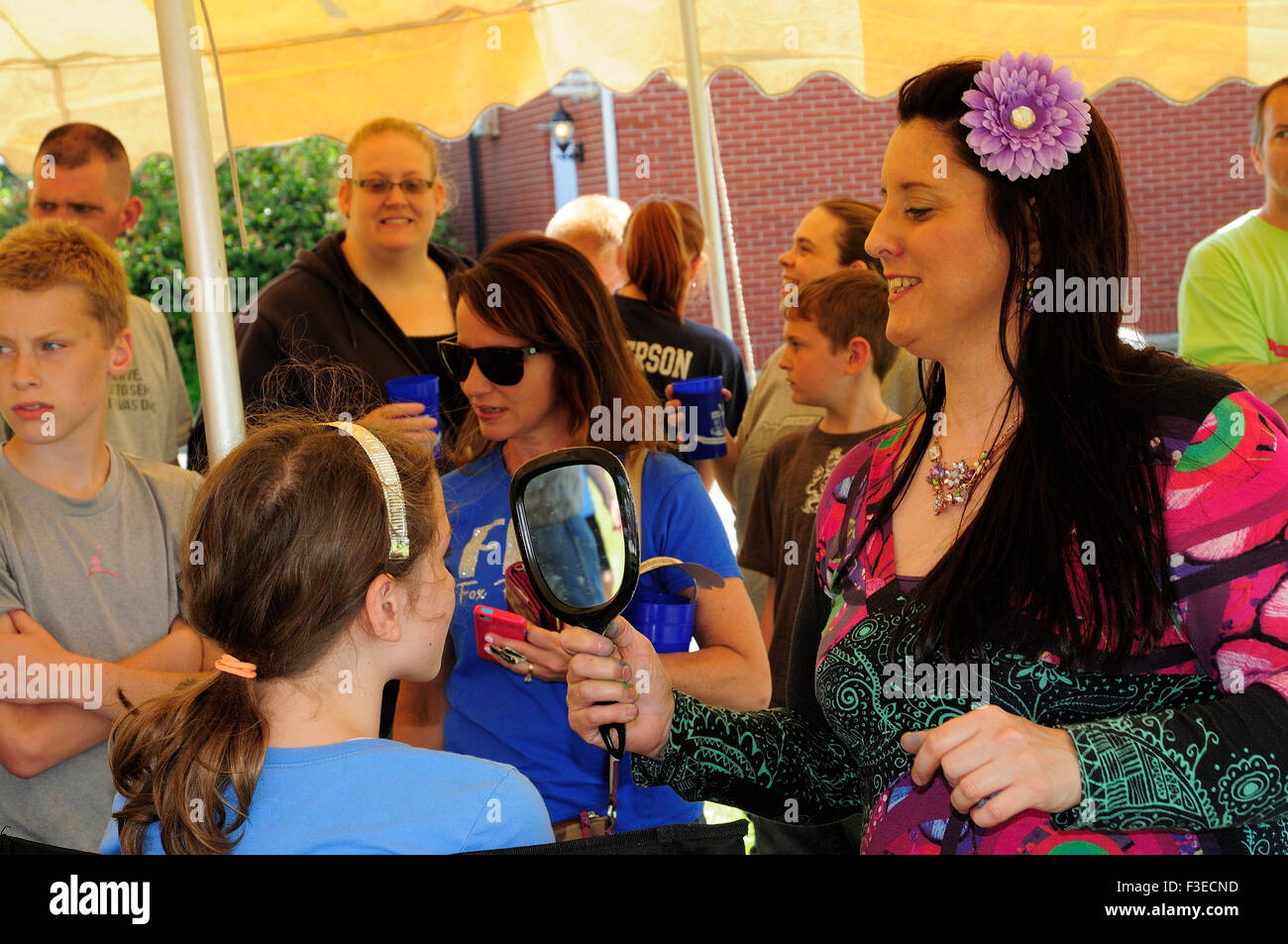Young Girls looking at finished face painting at local festival Stock ...