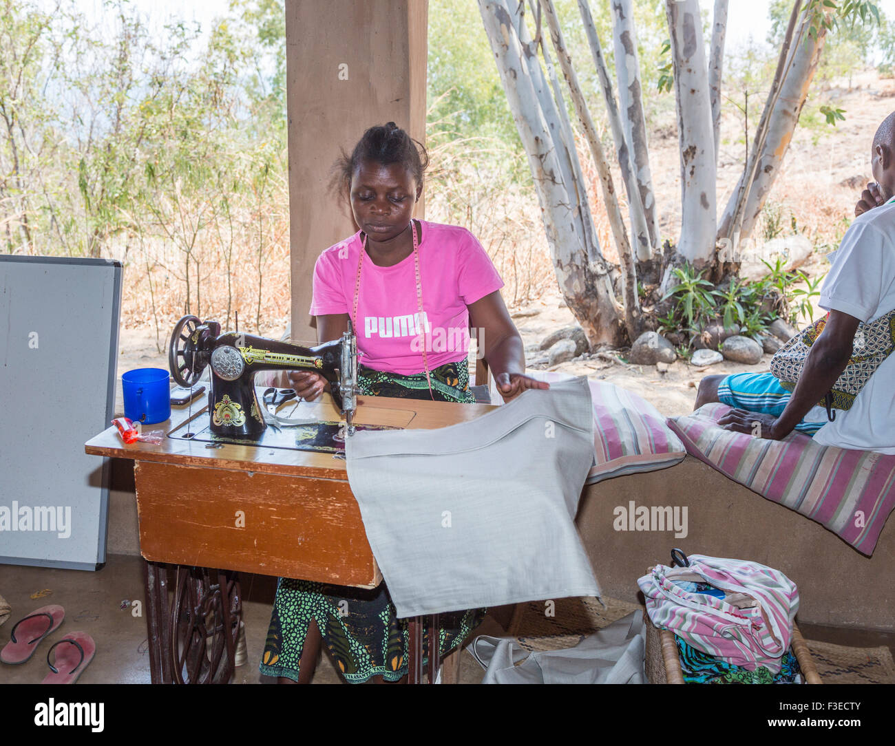 Local African woman sewing with a vintage sewing machine at Katundu ...