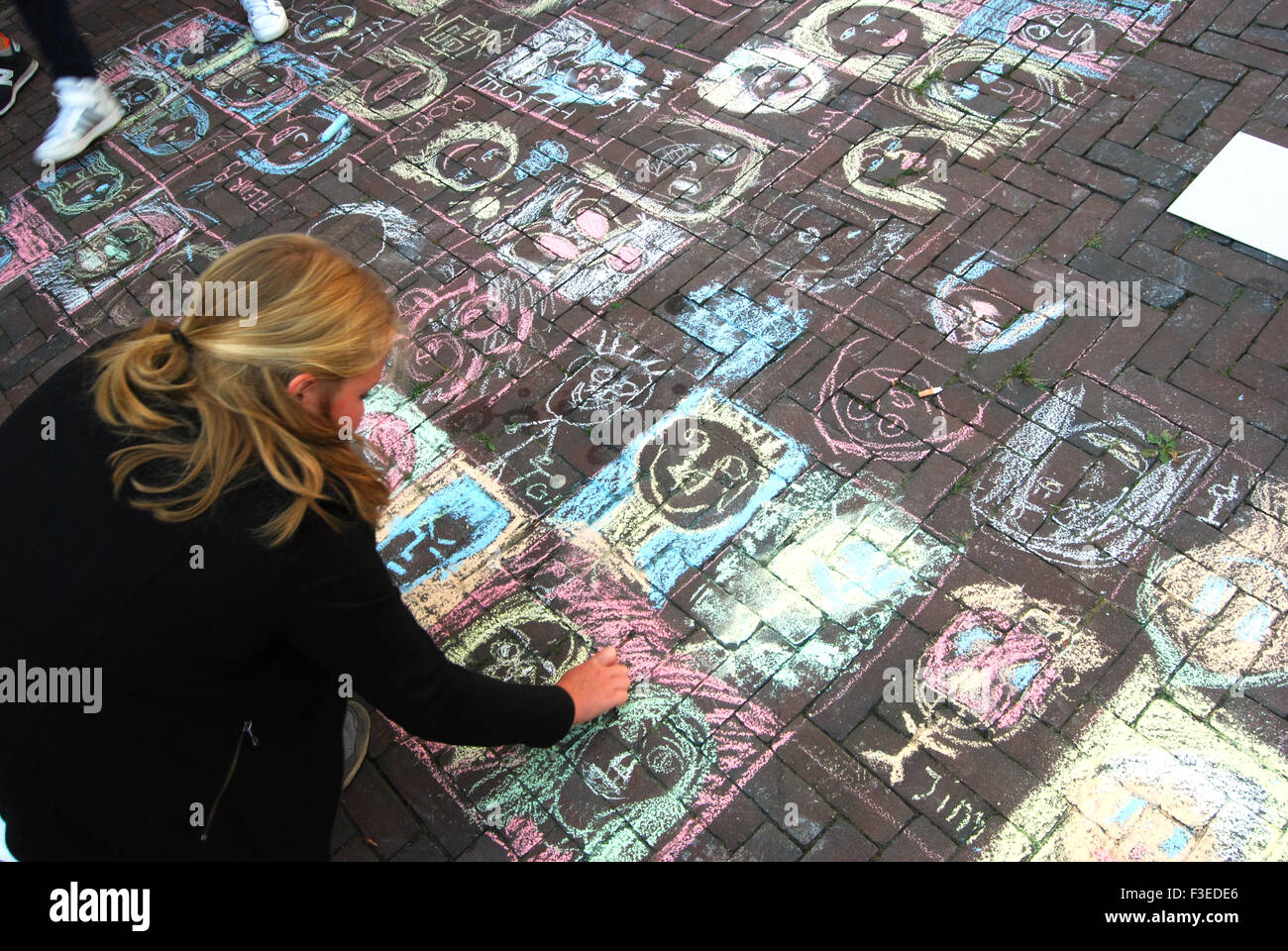 girl drawing chalk faces in the street Stock Photo - Alamy
