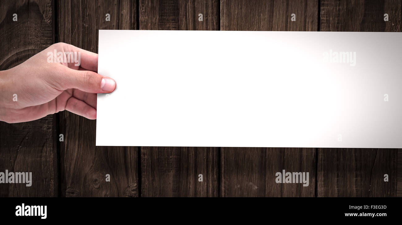 Hand holding paper against wooden wall Stock Photo - Alamy
