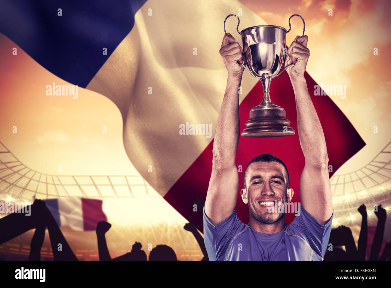 Composite image of portrait of smiling rugby player holding trophy ...