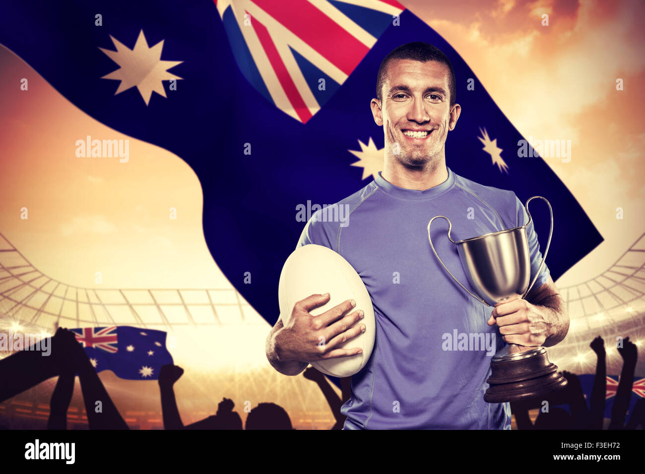 Composite image of portrait of smiling rugby player holding trophy and ...