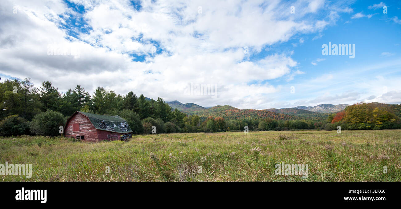 Old run down barn with fall color in the Adirondacks in the background ...