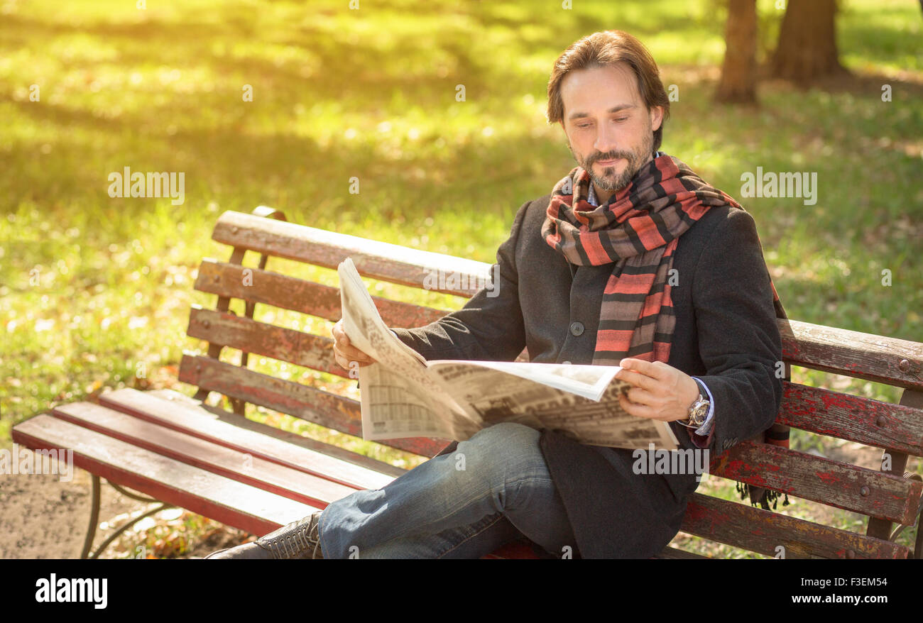 Man reading newpaper in the park Stock Photo - Alamy